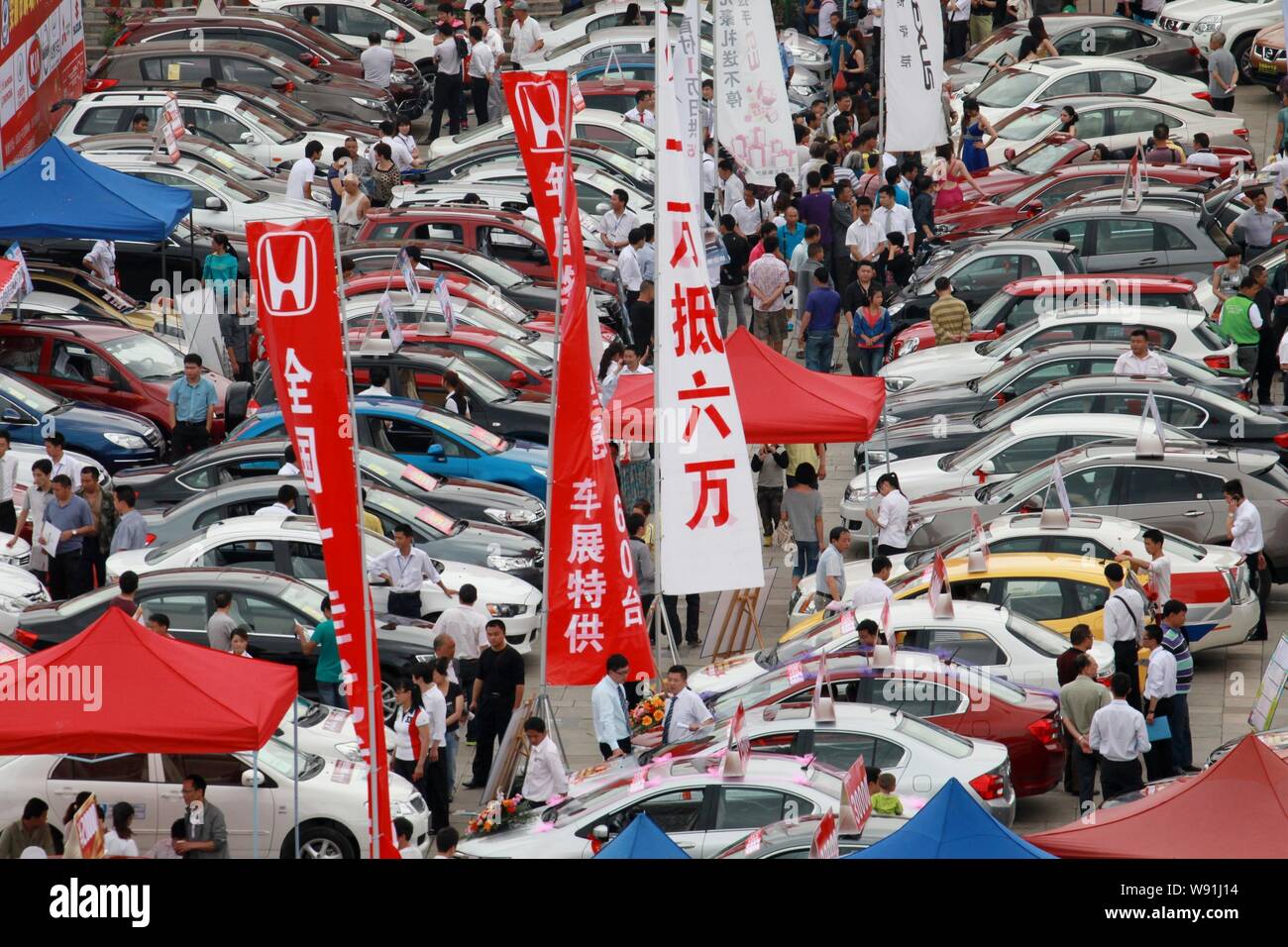 Chinese visitors look at cars during an auto show in Anshun city ...