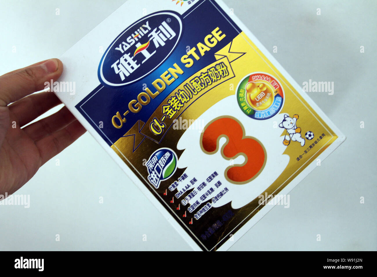 --FILE--A shopper shows a carton of Yashili Golden Stage infant milk ...