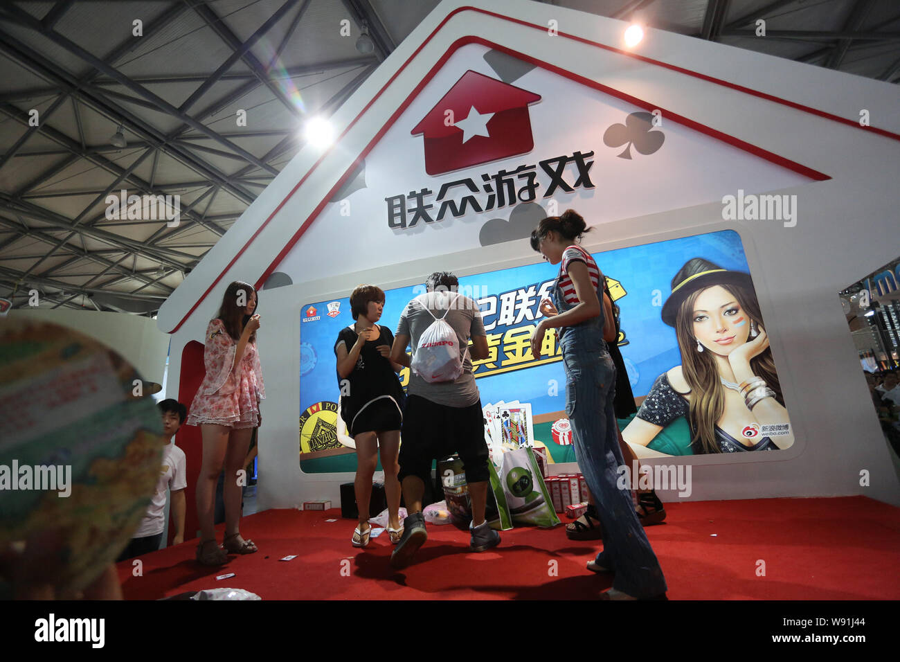 --FILE--Chinese visitors look at exhibits at the stand of Ourgame ...