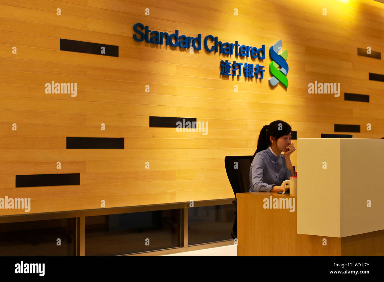 --FILE--A Chinese employee works at a branch of London-listed Standard ...