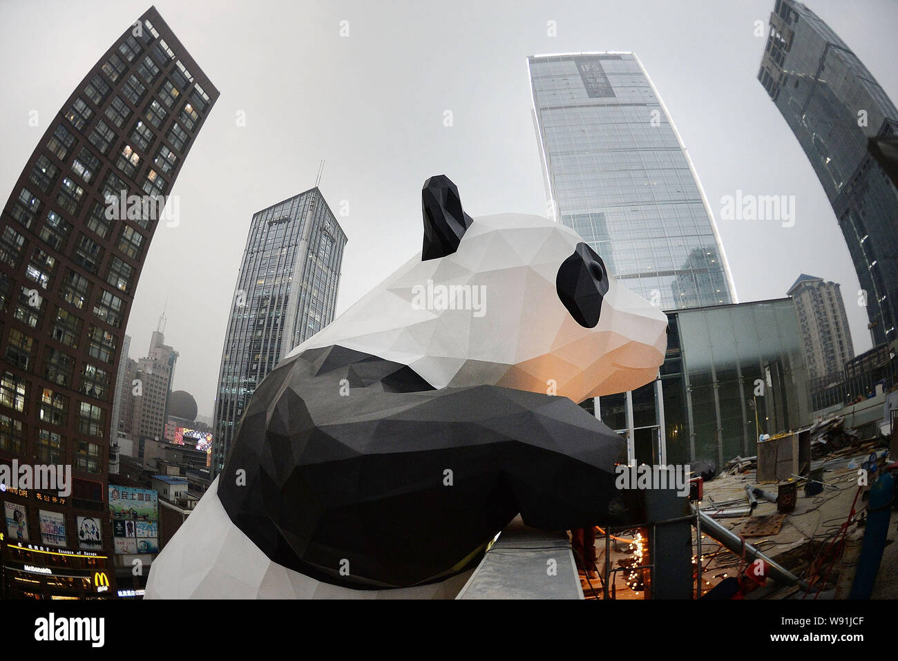 A giant panda-shaped art installation is being installed on the facade ...