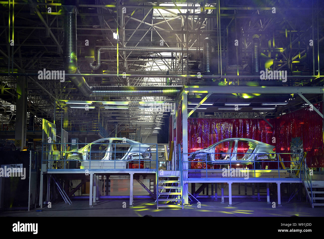 The body frames of two Volvo S60L cars are displayed on the assembly ...