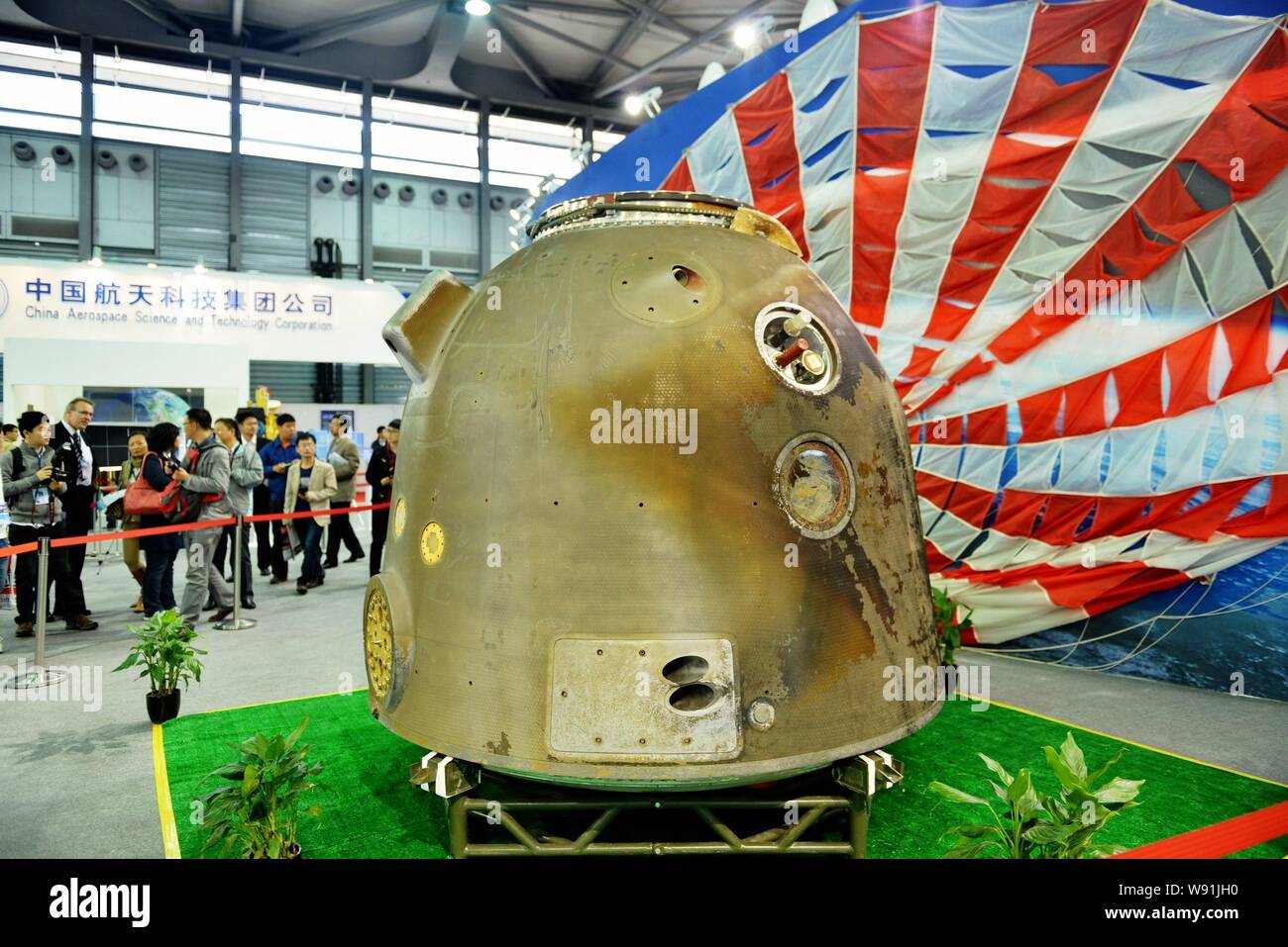 Visitors look at the re-entry capsule which carried the three ...