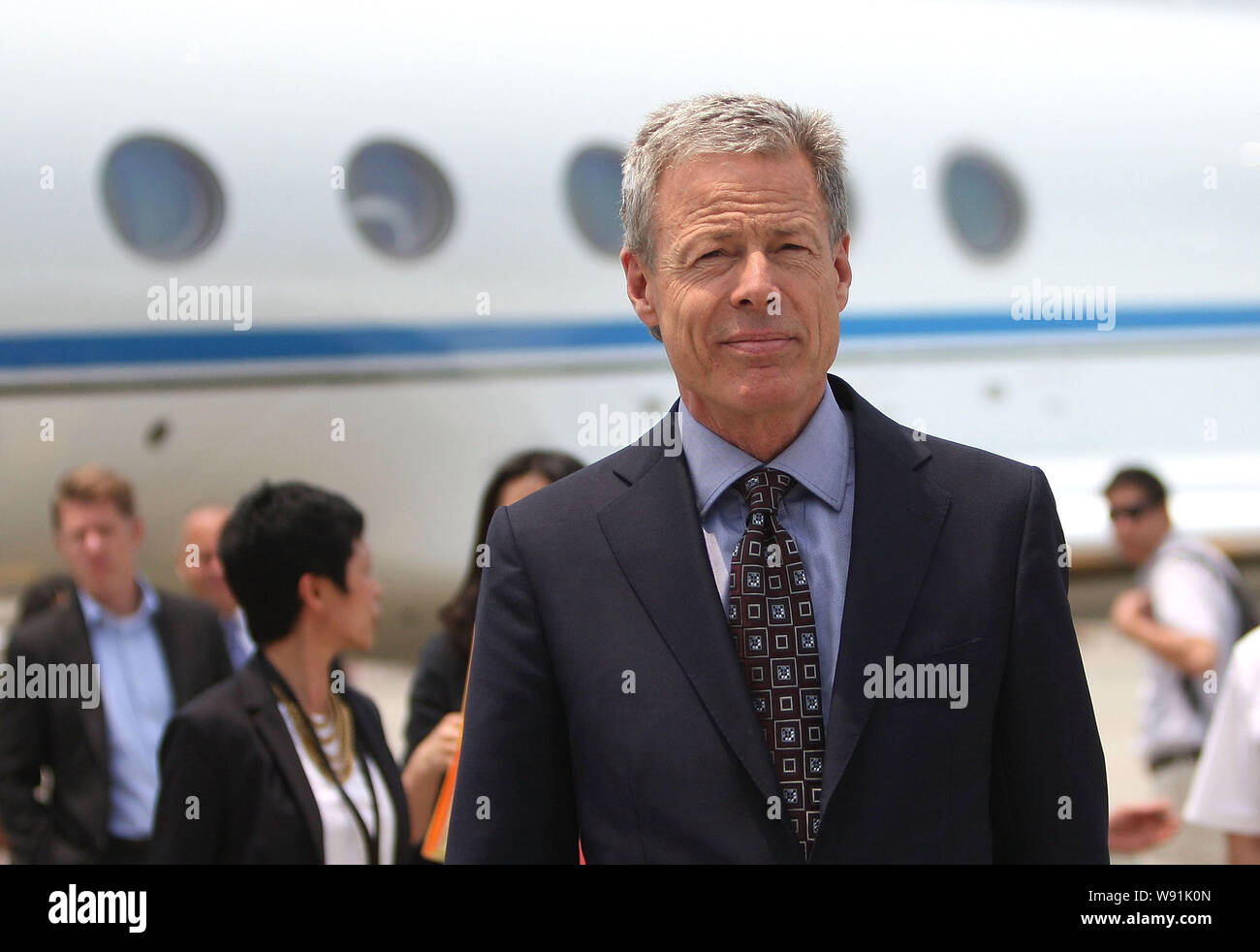 Jeff Bewkes, front, CEO of Time Warner, looks on after deplaning from a ...