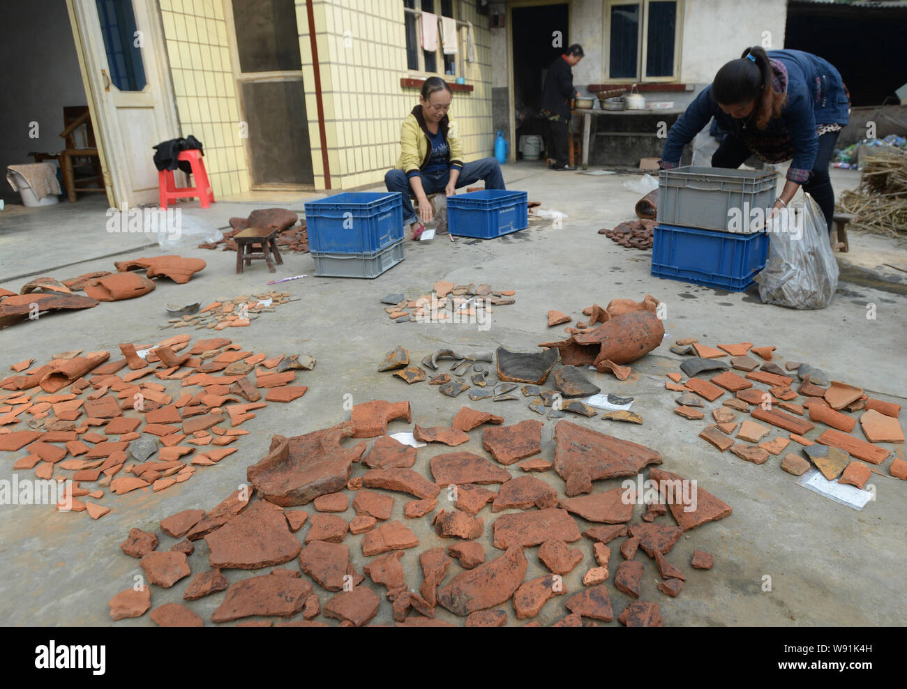 Chinese workers clean up broken pieces of pottery wares unearthed from ...