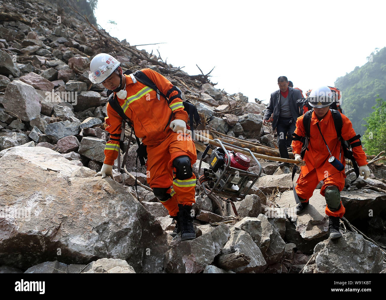 Chinese rescuers carry an electric generator as they pass through the ...