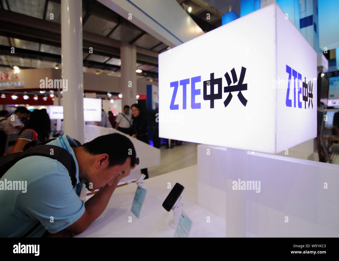 --FILE--Visitors try out ZTE smartphones during PT/EXPO COMM CHINA 2012 ...