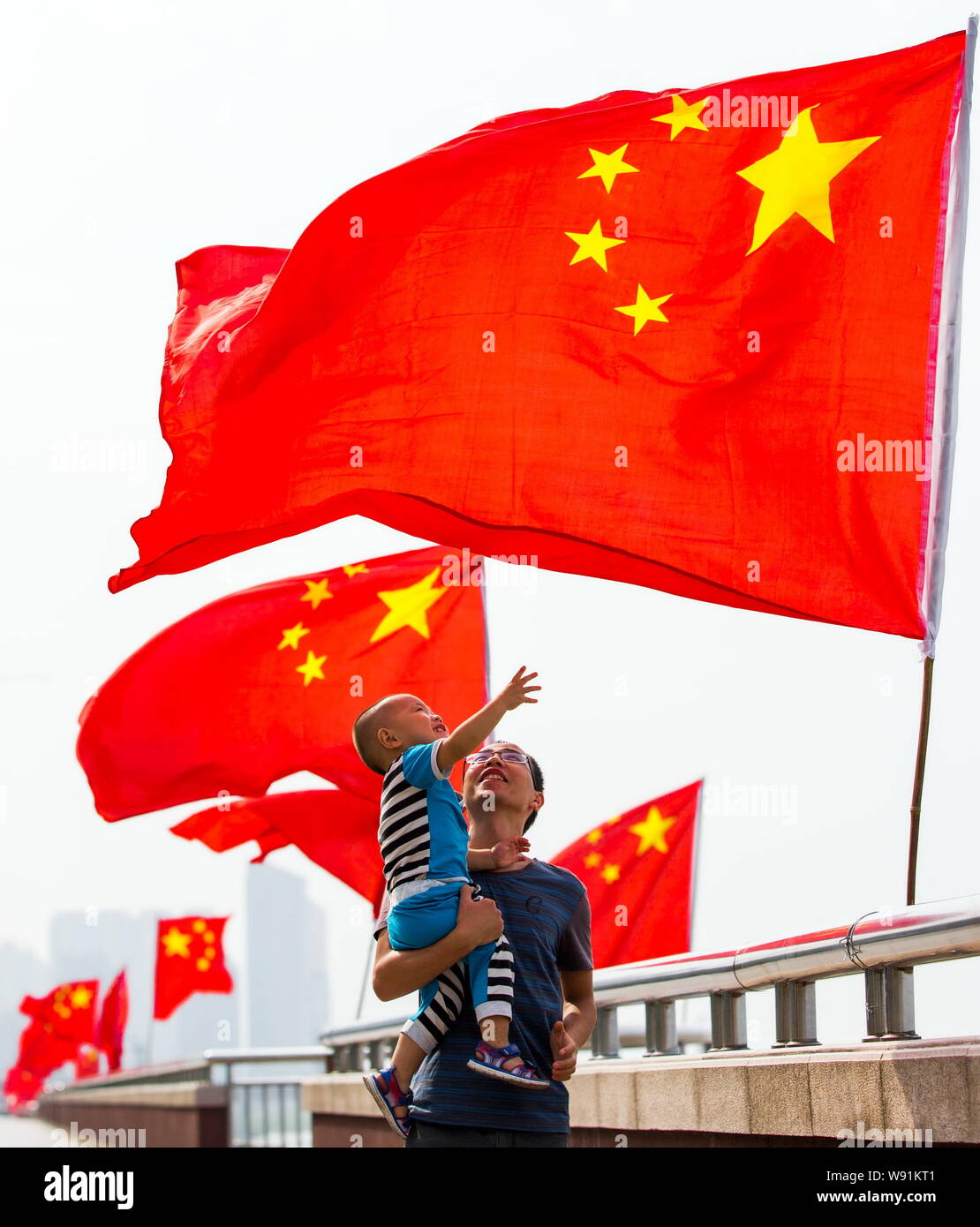 Chinese people smile as they look at Chinese national flags fluttering ...