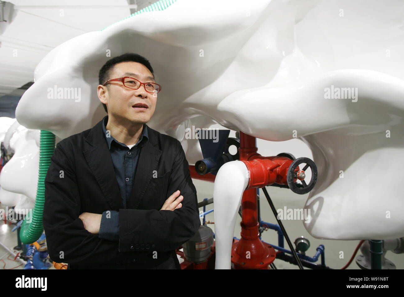 --FILE--Chinese artist Wang Jianwei poses next to one of his artworks at an art exhibition in ...