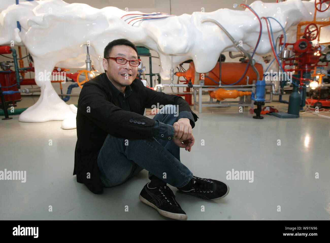 --FILE--Chinese artist Wang Jianwei poses next to one of his artworks at an art exhibition in ...