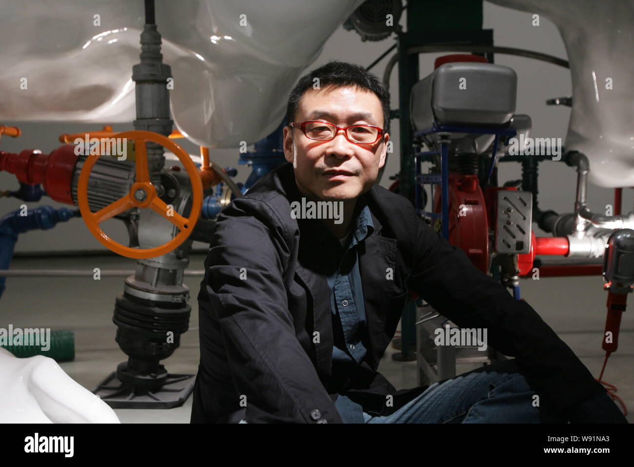 --FILE--Chinese artist Wang Jianwei poses next to one of his artworks at an art exhibition in ...