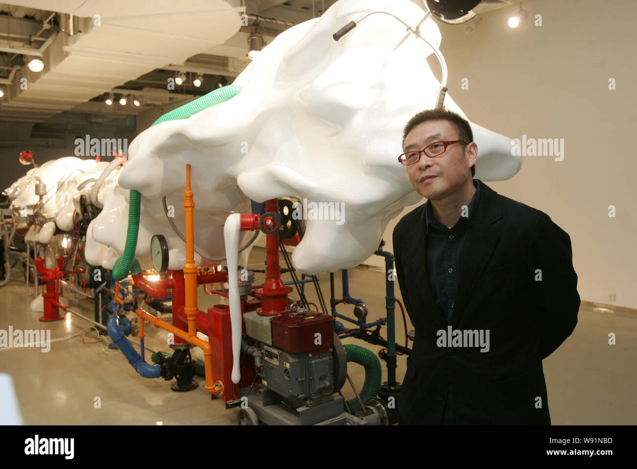 --FILE--Chinese artist Wang Jianwei poses next to one of his artworks at an art exhibition in ...