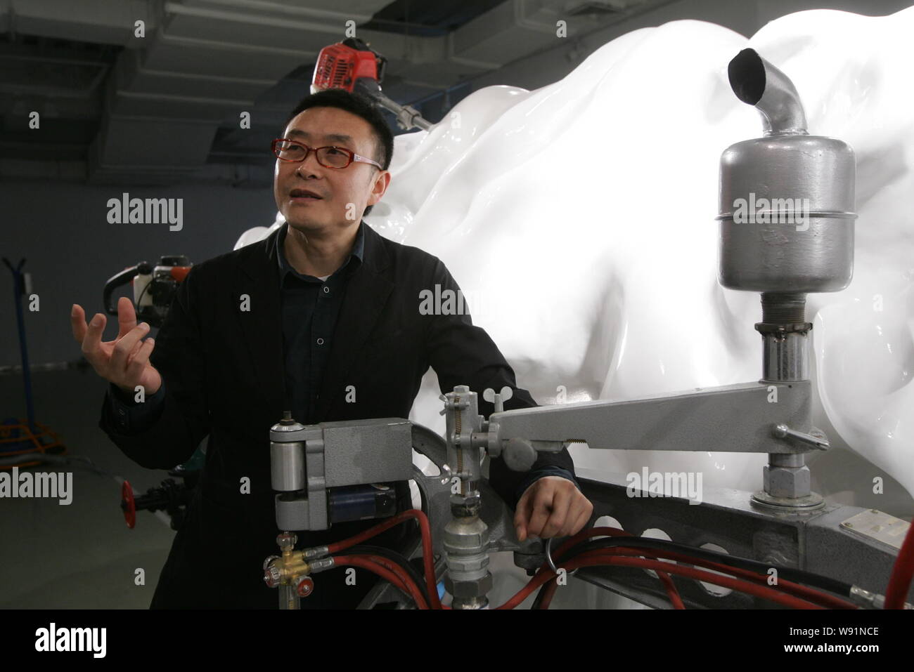 --FILE--Chinese artist Wang Jianwei speaks next to one of his artworks at an art exhibition in ...