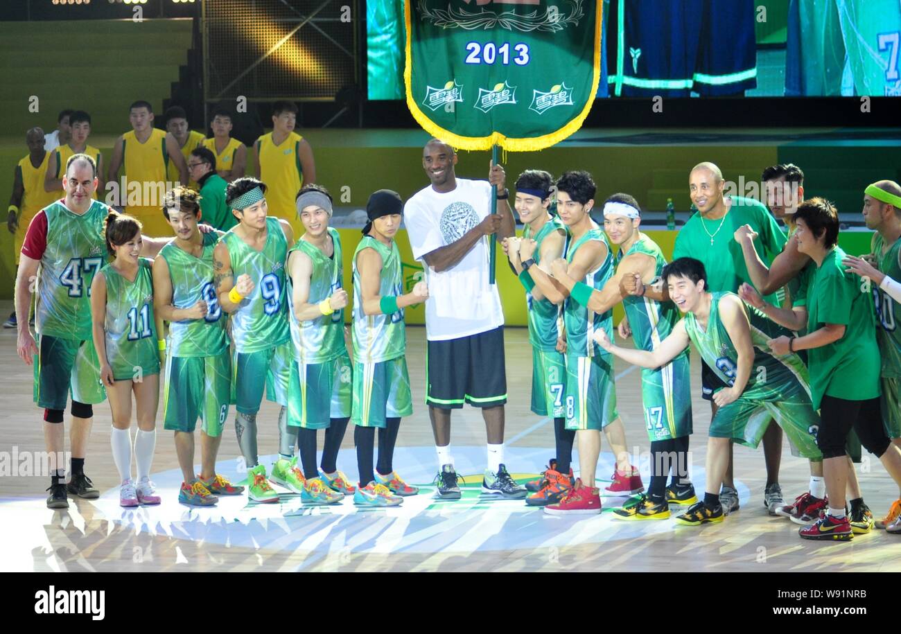 NBA star Kobe Bryant, center, poses for photos during a basketball ...