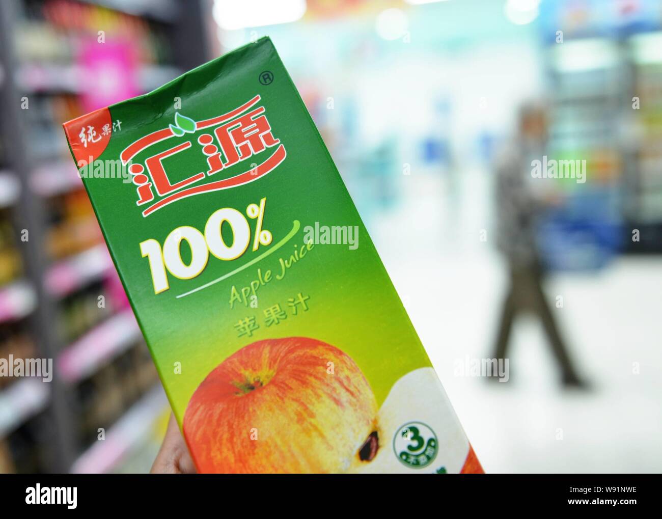 A customer buys a carton of Huiyuan apple juice at a supermarket in ...