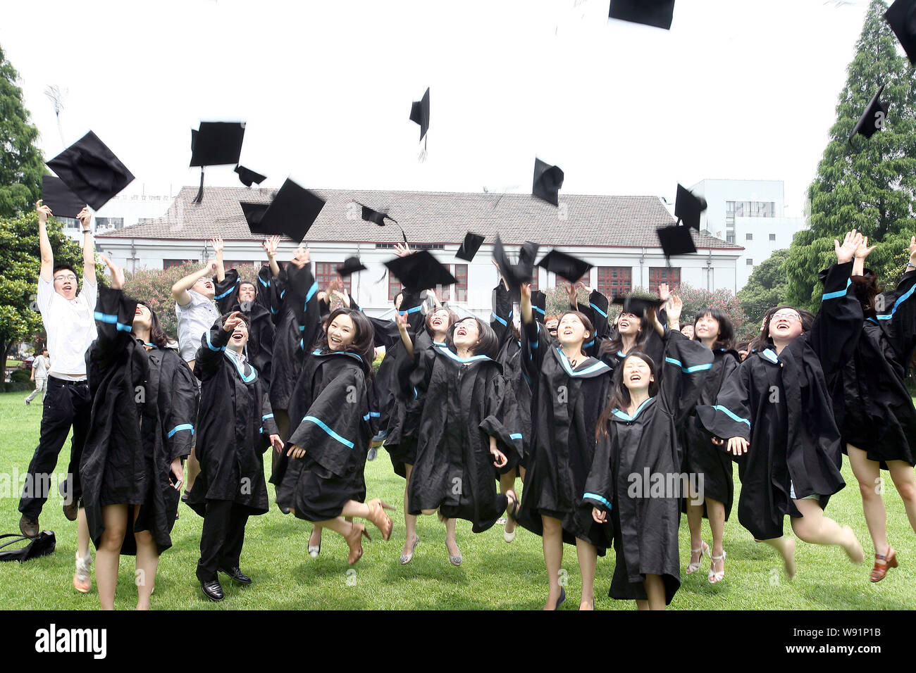 --FILE--Chinese graduates throw their academic hats into the air after ...