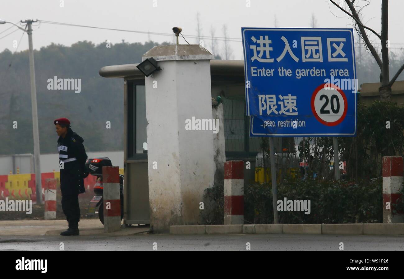A Chinese security guard stands at an entrance to the construction site ...