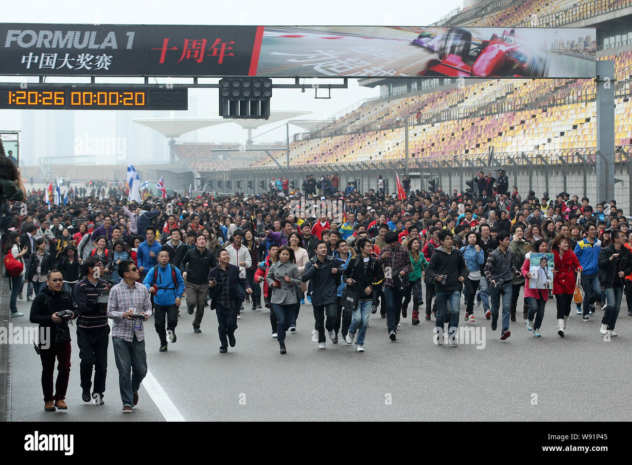 A crowd of Formula One fans run on the track during a celebration for ...