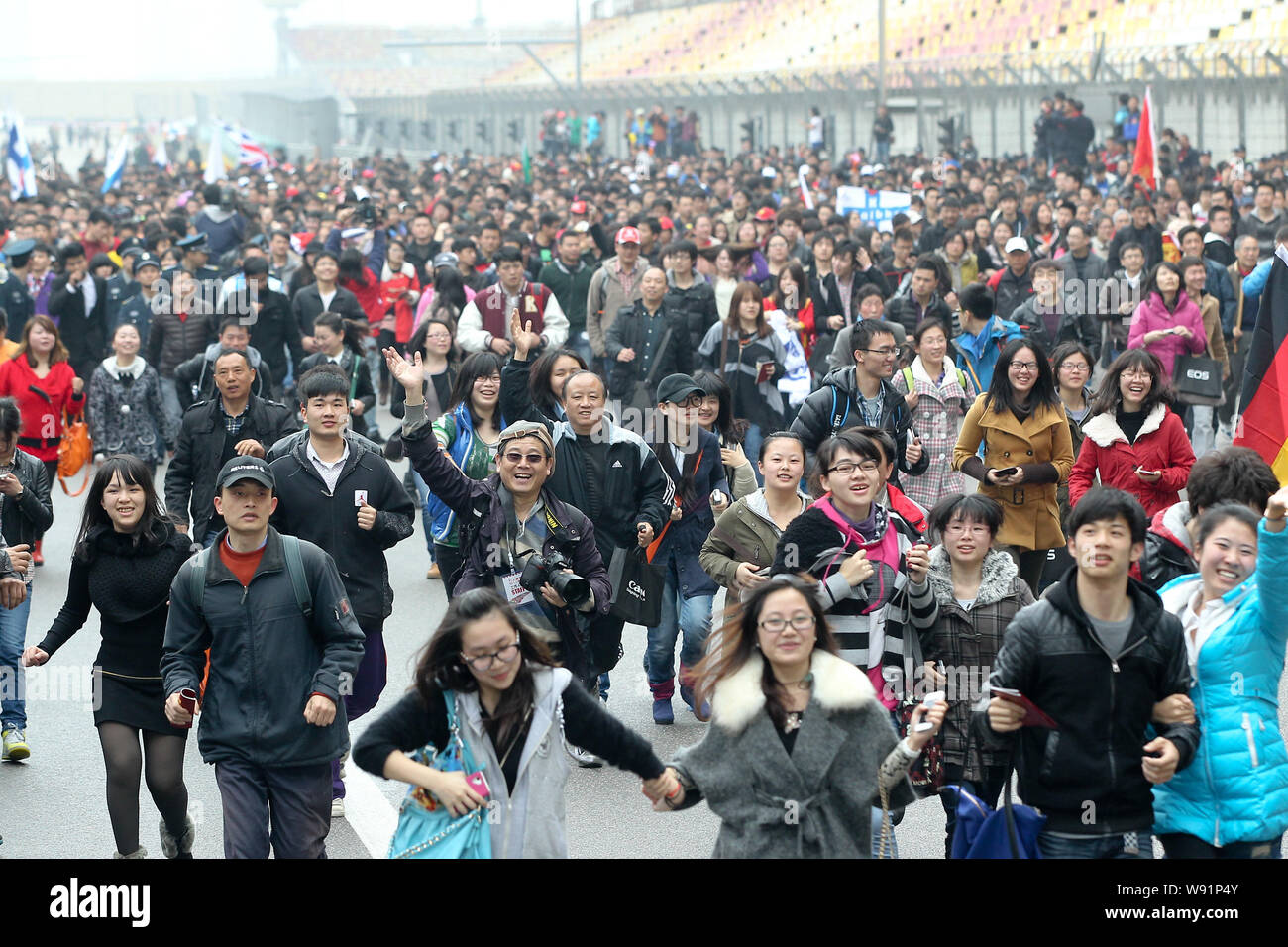 A crowd of Formula One fans run on the track during a celebration for ...