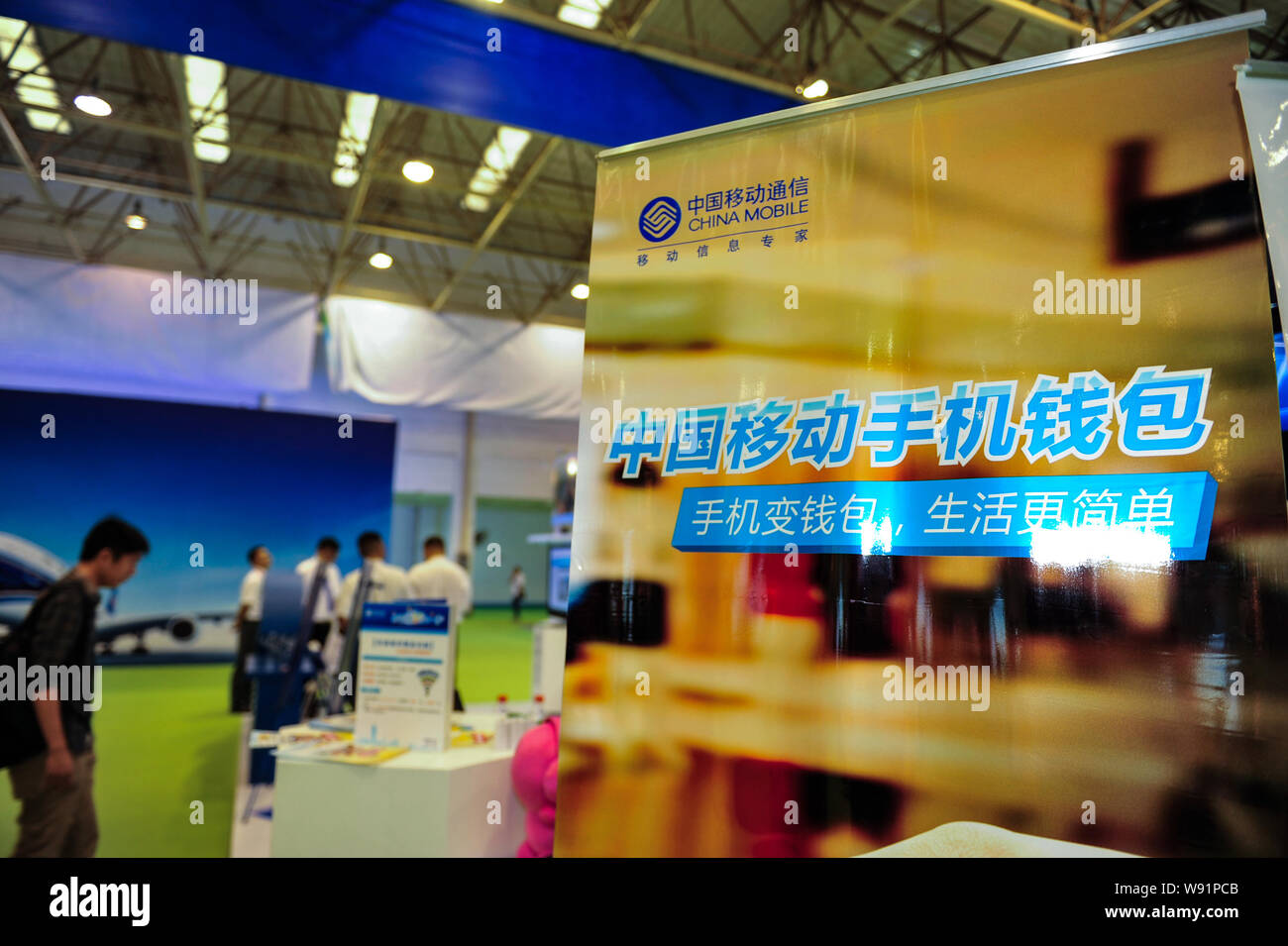 People visit the stand of China Mobile during an exhibition in Guilin ...