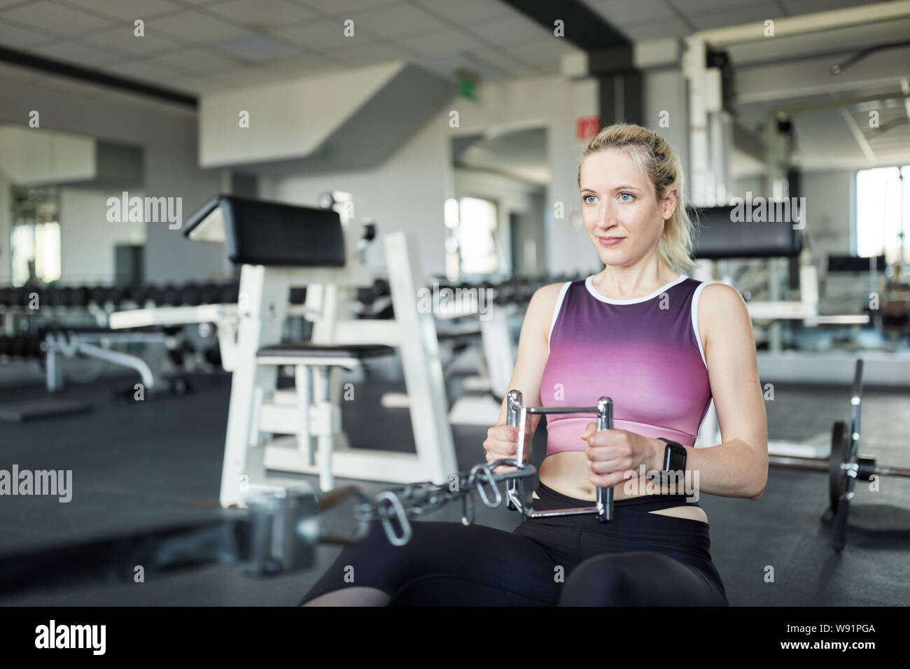 Woman rowing on cable with tight grip as strength training for the back ...