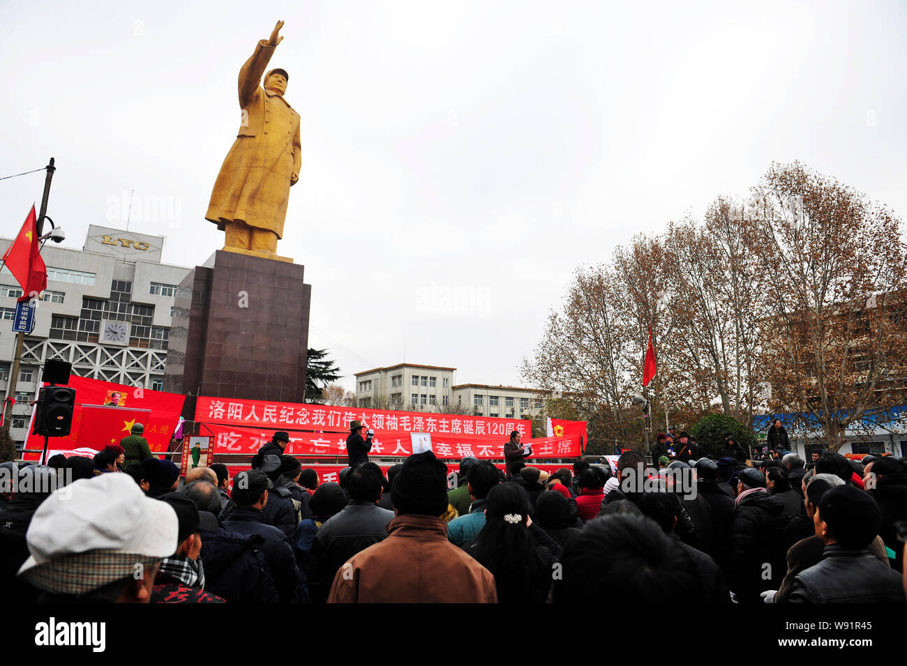 People gather in front of a statue of Mao Zedong during a ceremony to ...