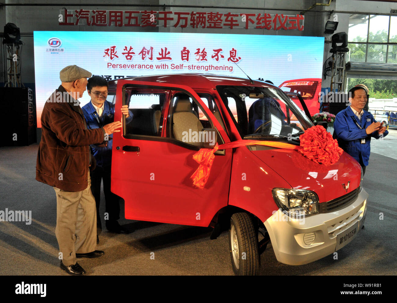 Chinese workers and executives exit a Wuling Sunshine minivan, the 10.1 ...
