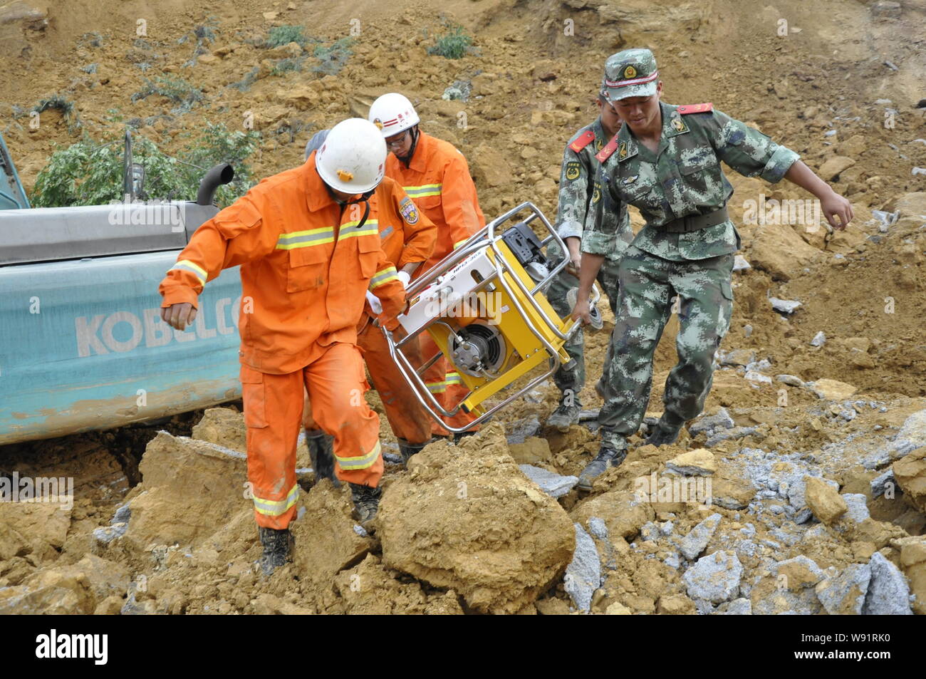 Chinese soldiers and rescuers carry rescue equipment to the scene after ...