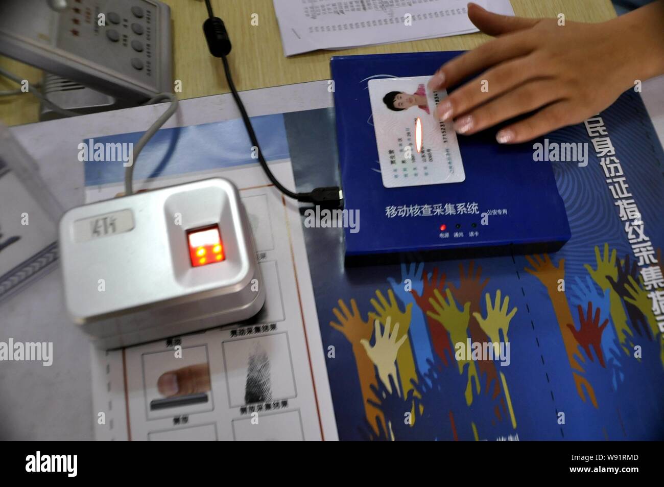 A police officer puts a second-generation ID card of a local resident ...