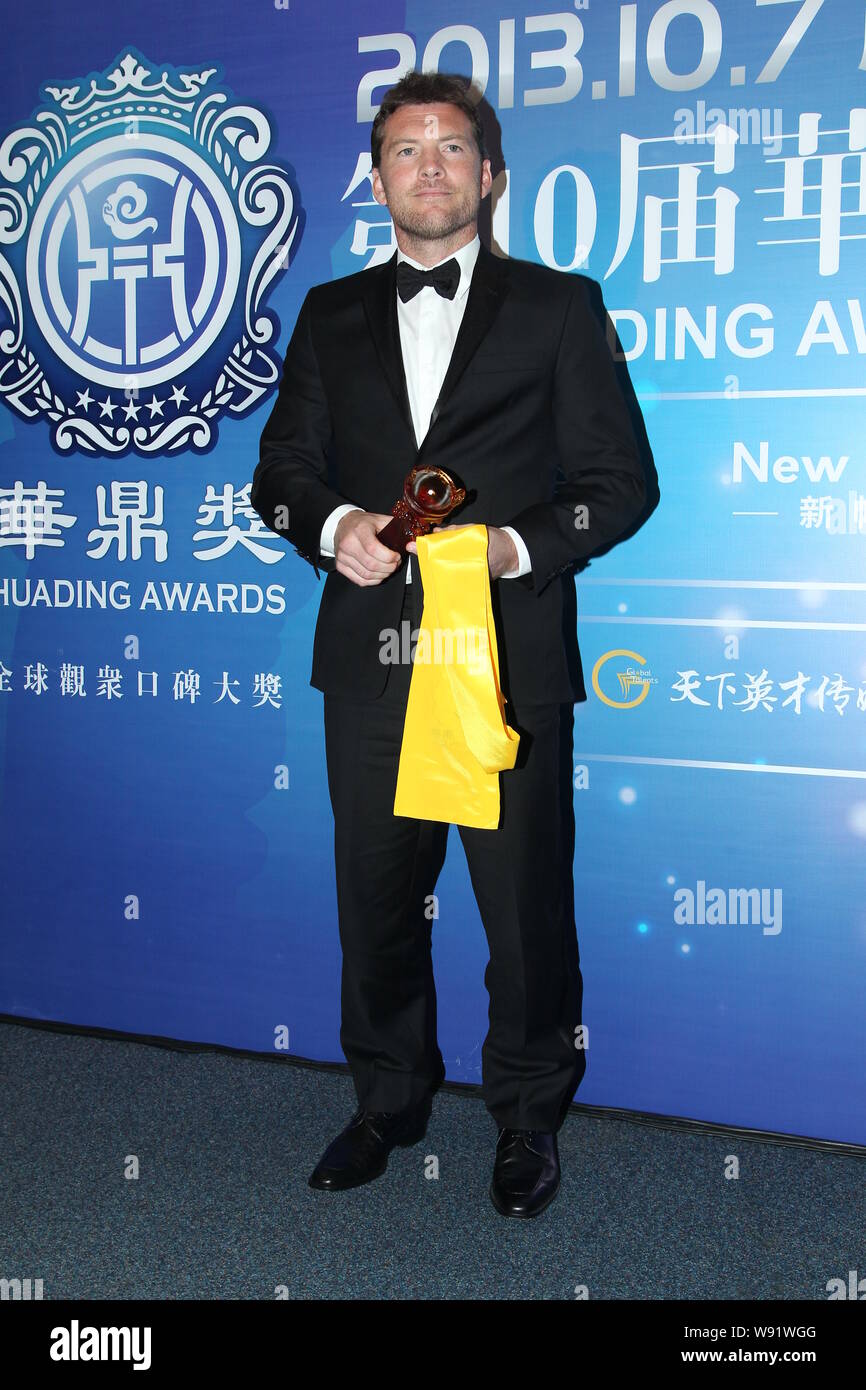 Australian actor Sam Worthington holds his trophy at the back stage of ...