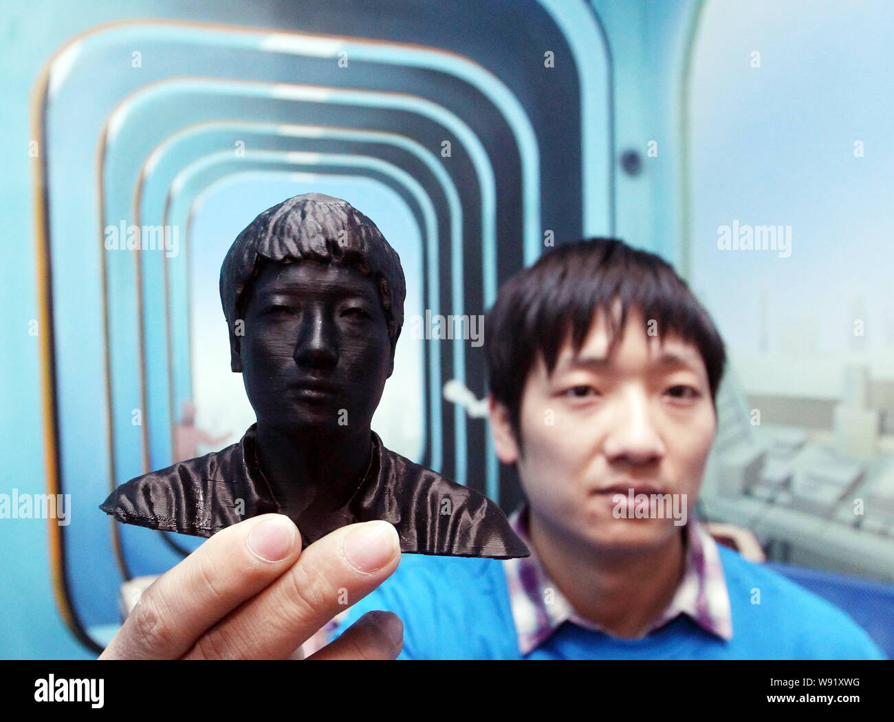 A staff shows his 3D reproduction in the first 3D photo printing ...