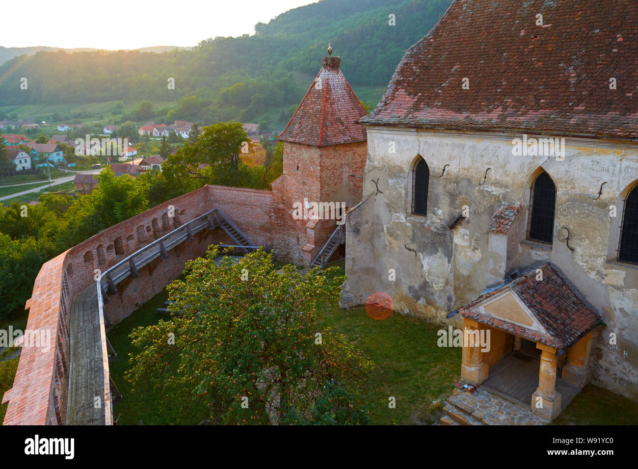 Aerial view of Alma Vii fortified church, with sun flare, at sunset ...