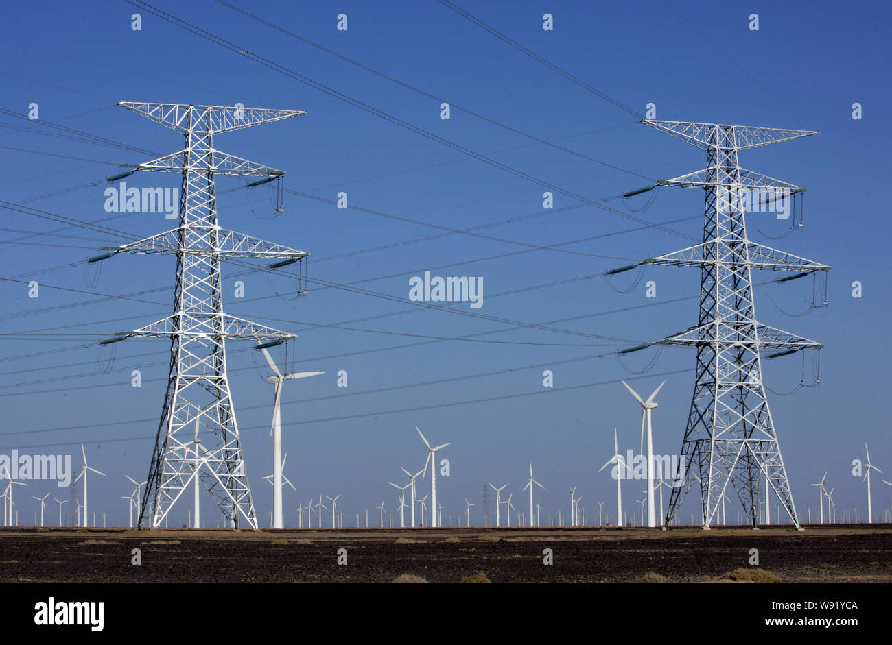 Power lines on pylons transmit electricity generated by the wind ...