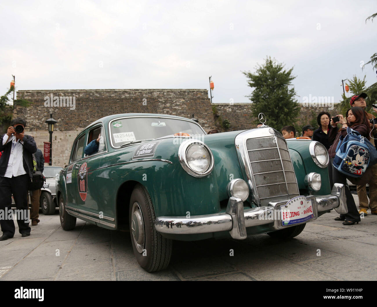 Visitors take photos of an old timer car of Mercedes-Benz during the ...