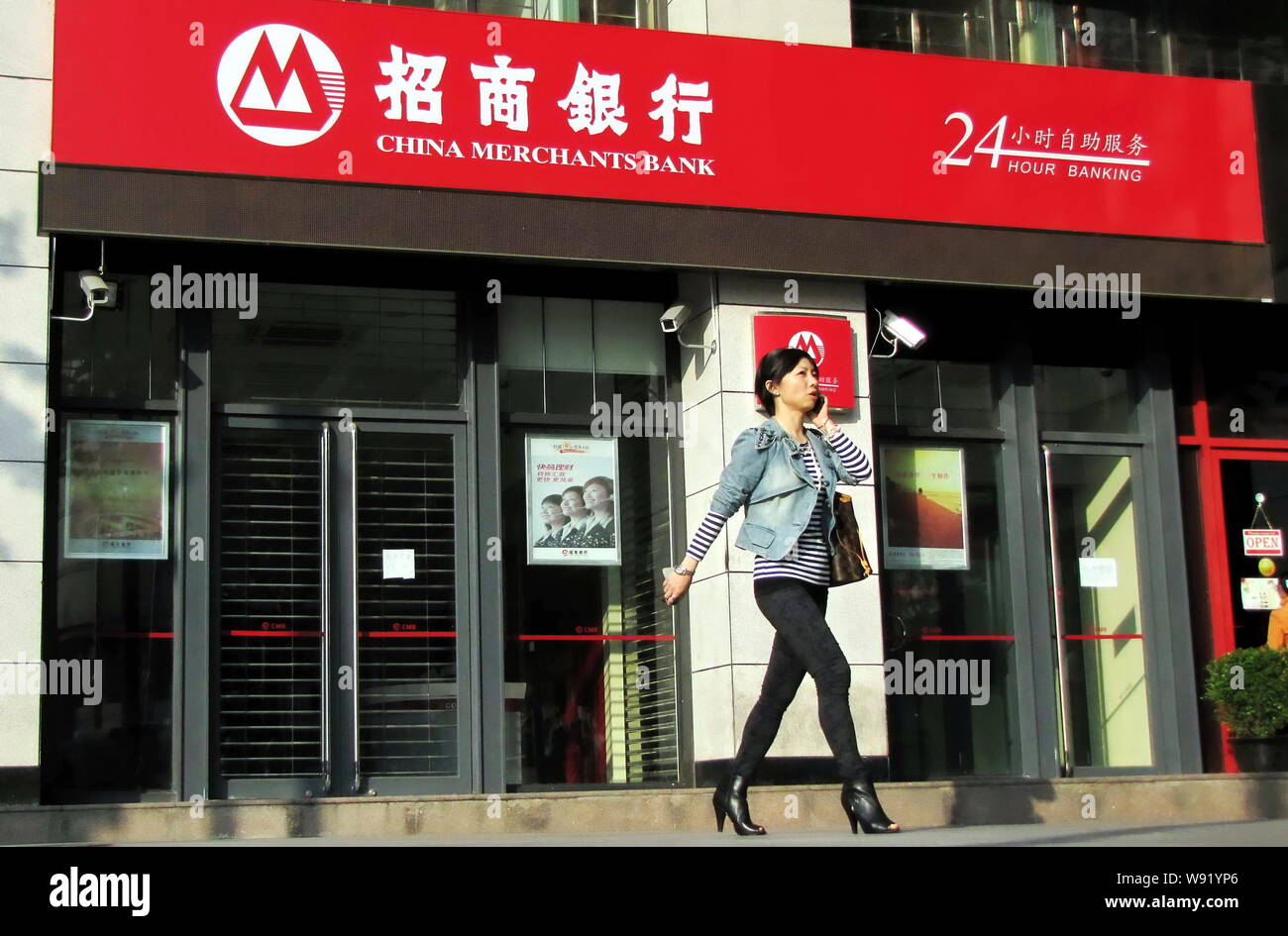 --FILE--A Chinese woman walks past a branch of China Merchants Bank ...