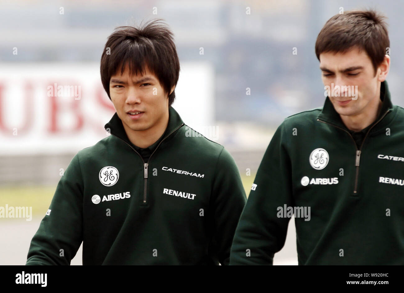 Chinese racer Ma Qinghua of Caterham, left, and his teammates walk ...