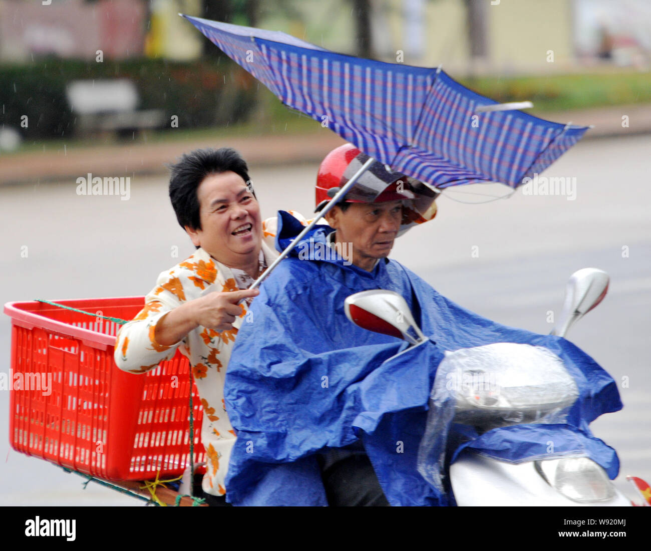 Chinese cyclists brave strong wind caused by Typhoon Haiyan in Qionghai ...
