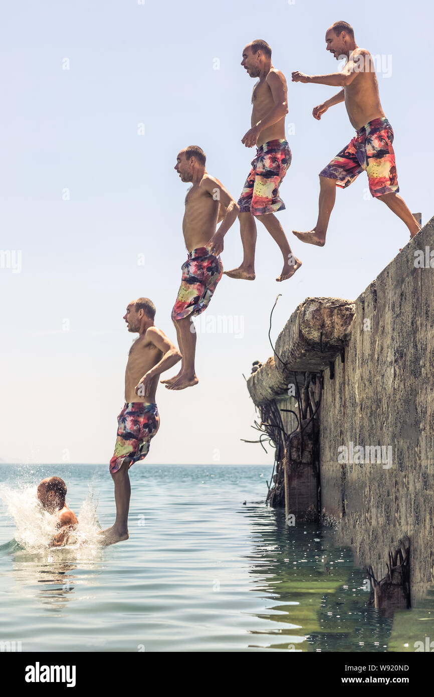 Man jumping from pier to sea Stock Photo - Alamy