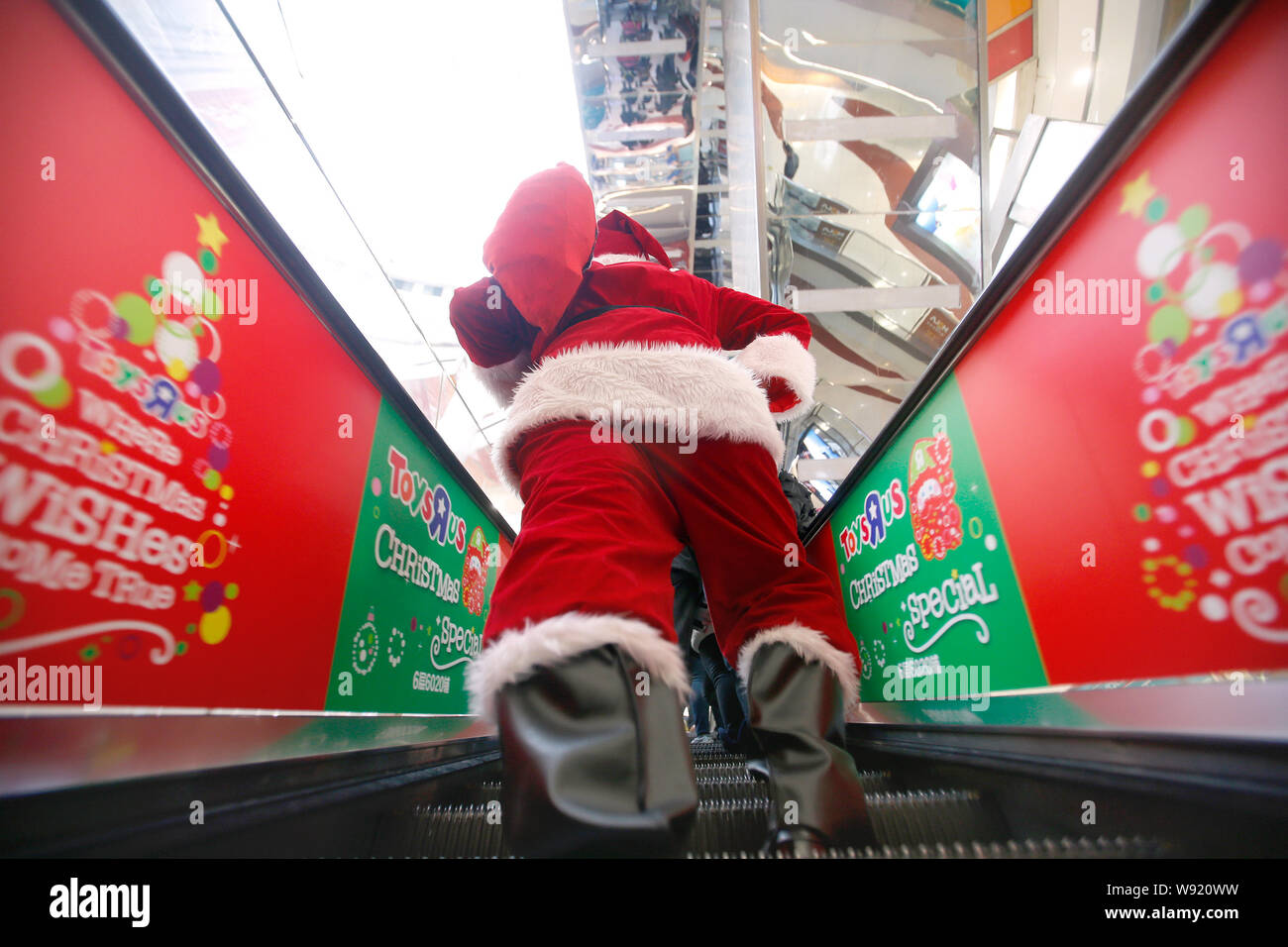 An entertainer dressed in the Santa Claus costume takes an escalator ...