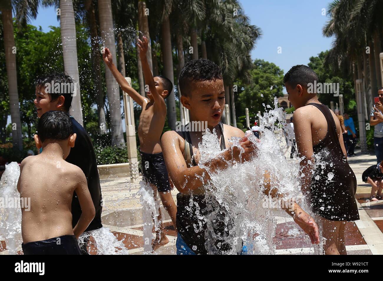 Cairo, Egypt. 12th Aug, 2019. Egyptian children play around a fountain ...