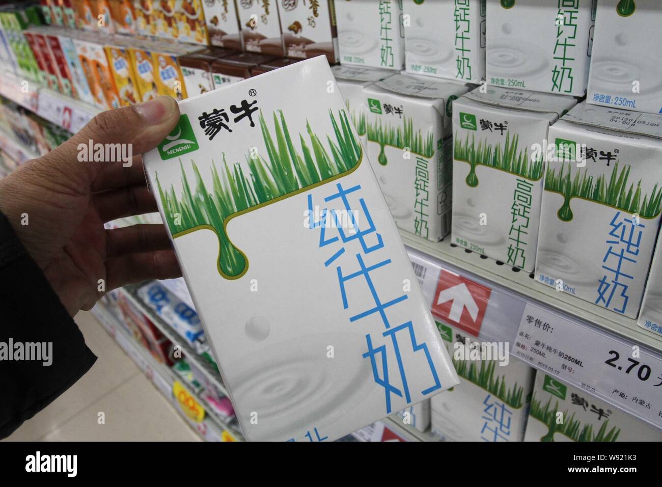 --FILE--A Chinese customer shops for Mengniu pure milk at a supermarket ...