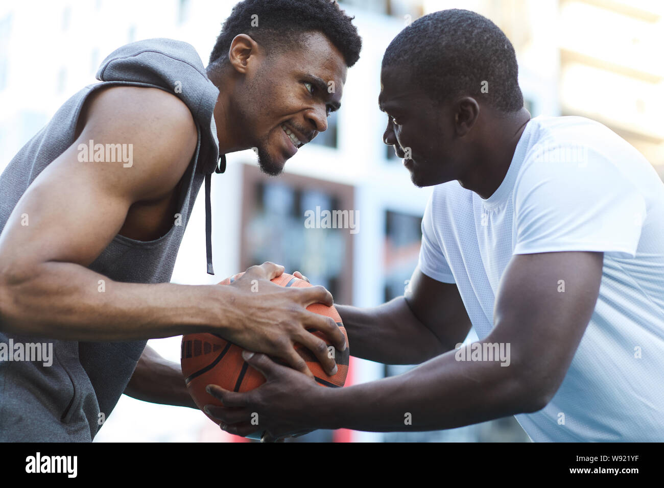 Portrait of two fierce African men fighting while playing basketball ...