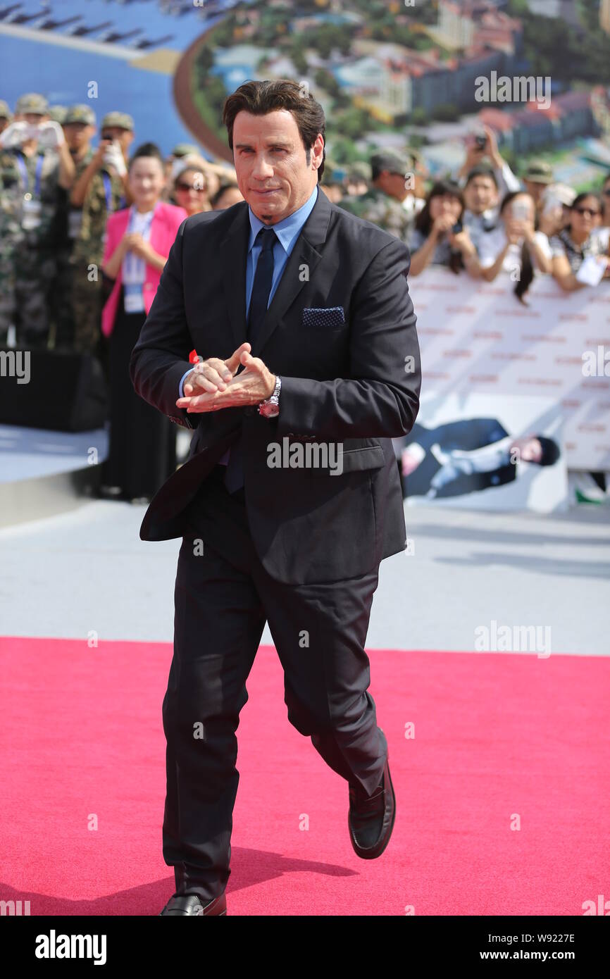 American actor John Travolta claps his hands on the red carpet as he ...