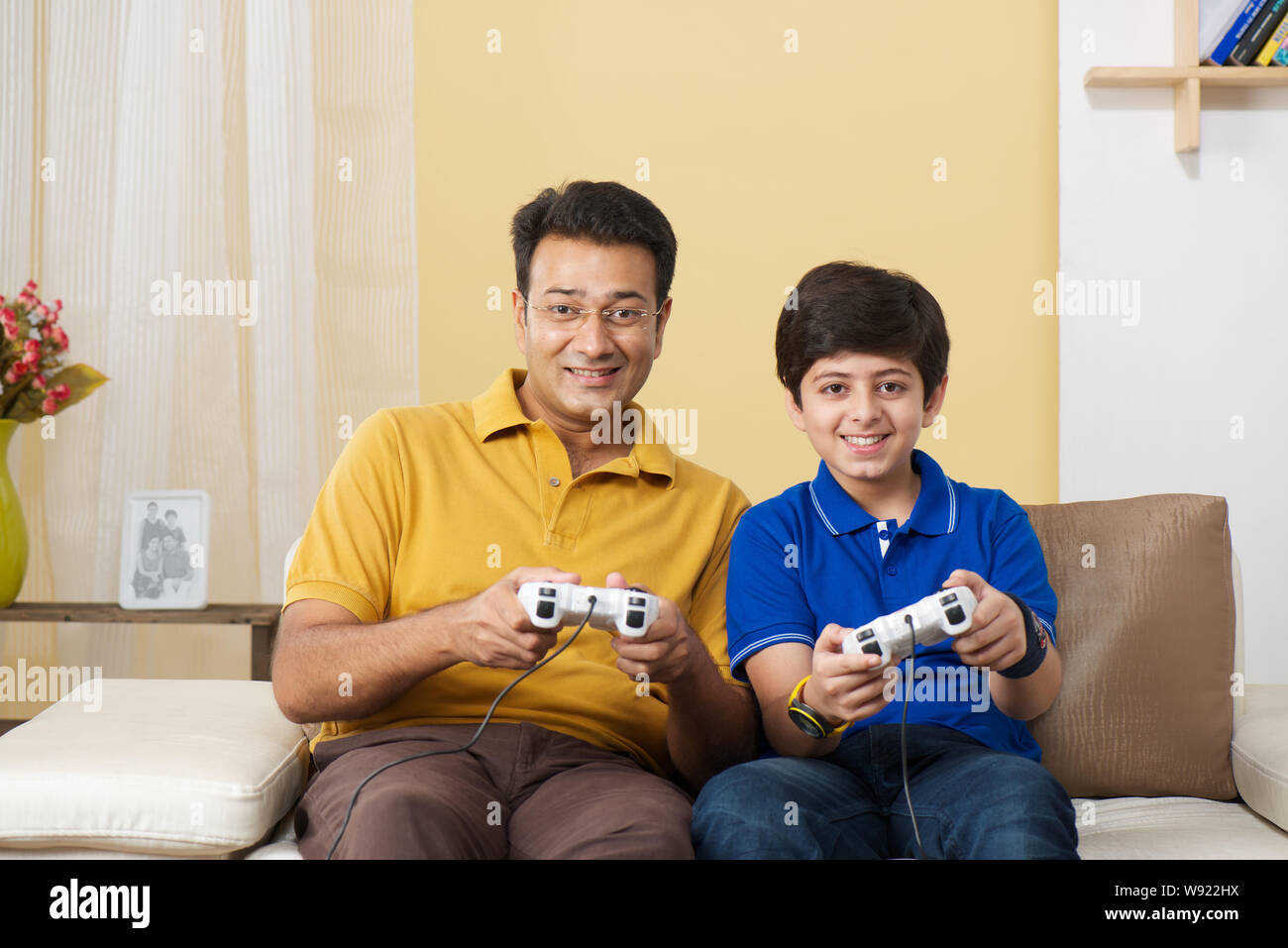 Father and son playing video game at home Stock Photo - Alamy