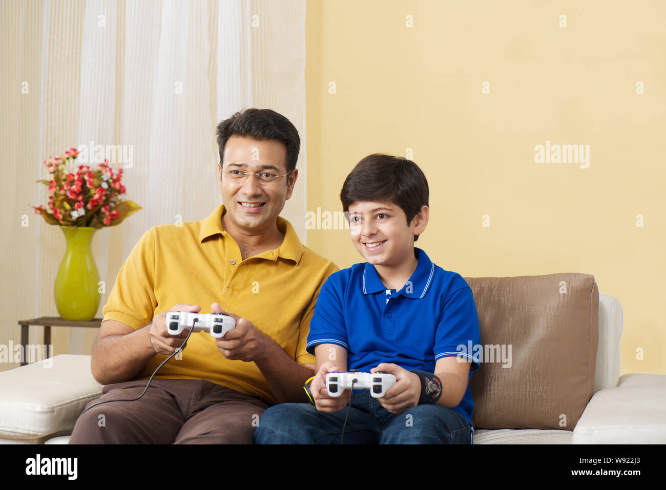 Father and son playing video game at home Stock Photo - Alamy
