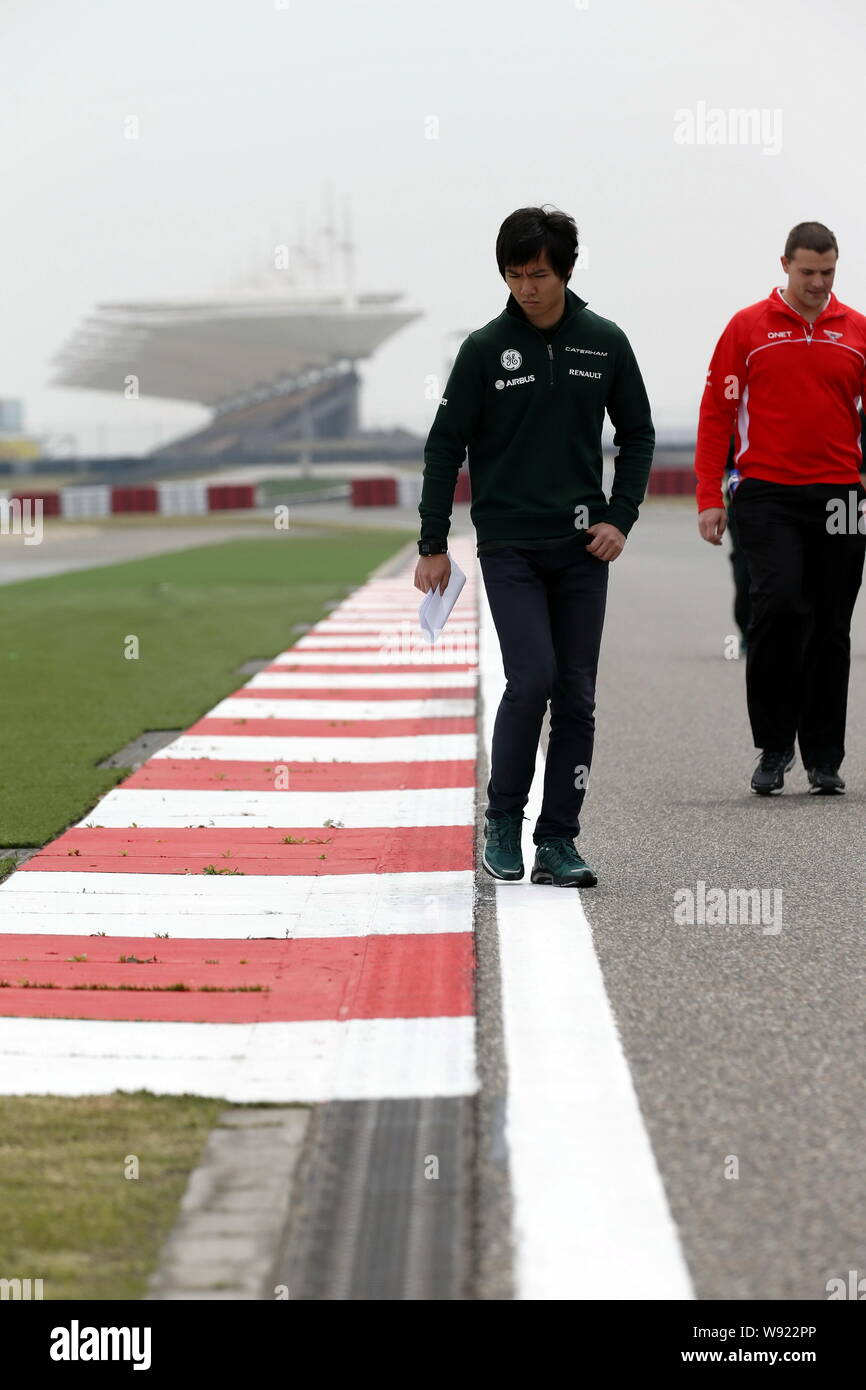 Chinese racer Ma Qinghua of Caterham, left, checks the track at the ...