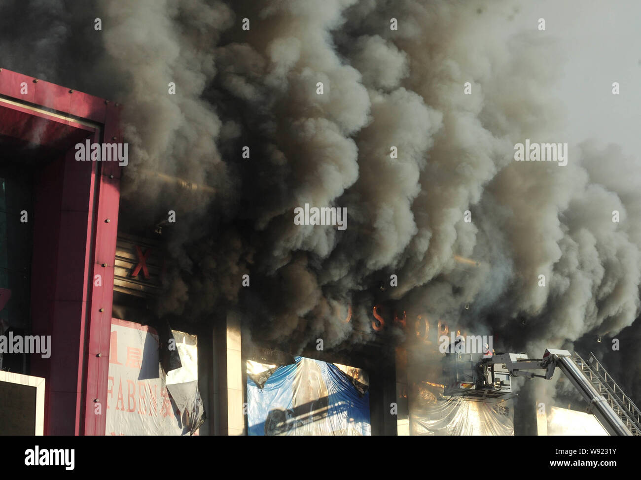 Chinese firefighters hose water to extinguish the fire in the Xilongduo ...