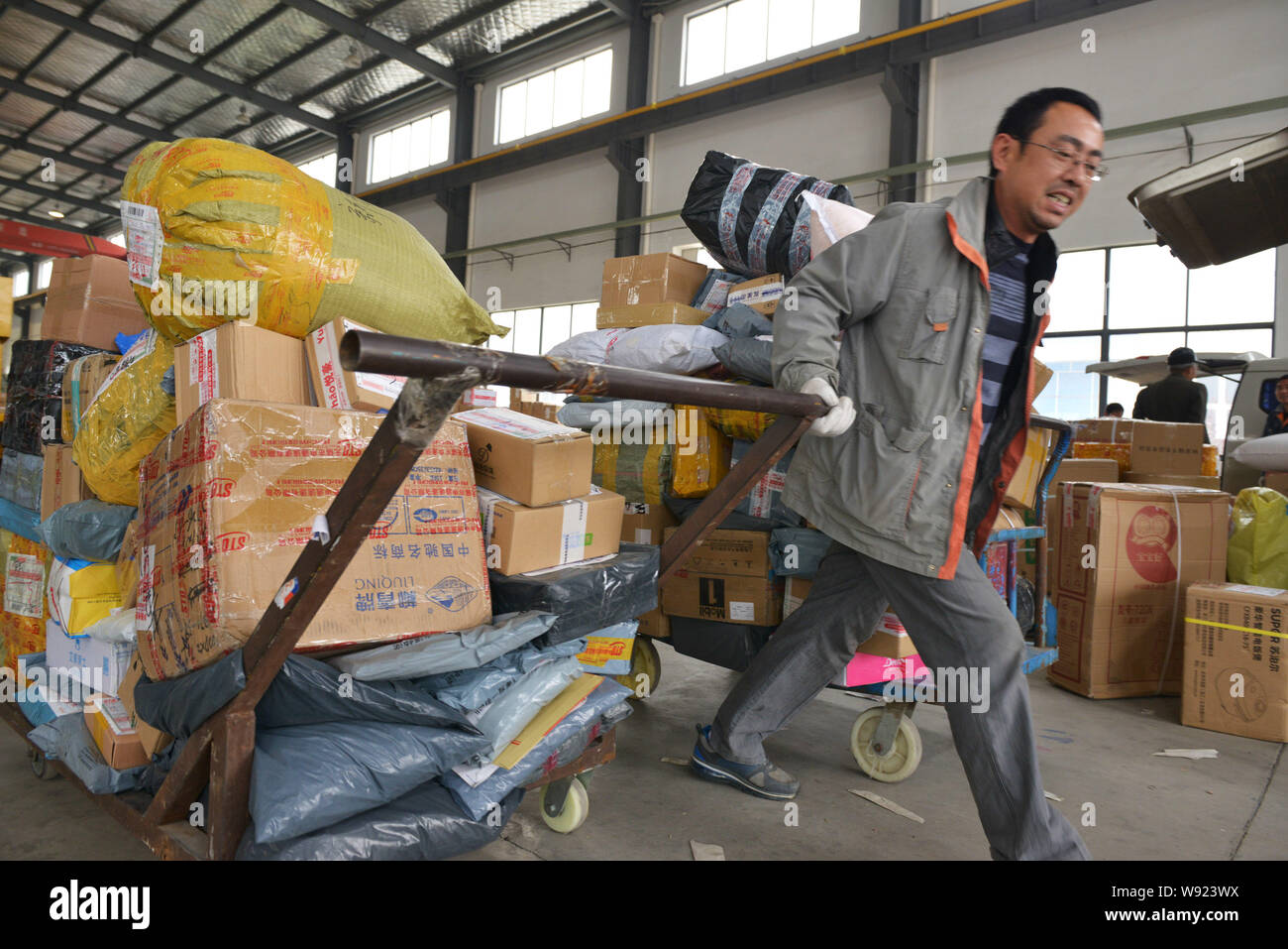 A Chinese worker carts parcels, most of which come from online shopping ...