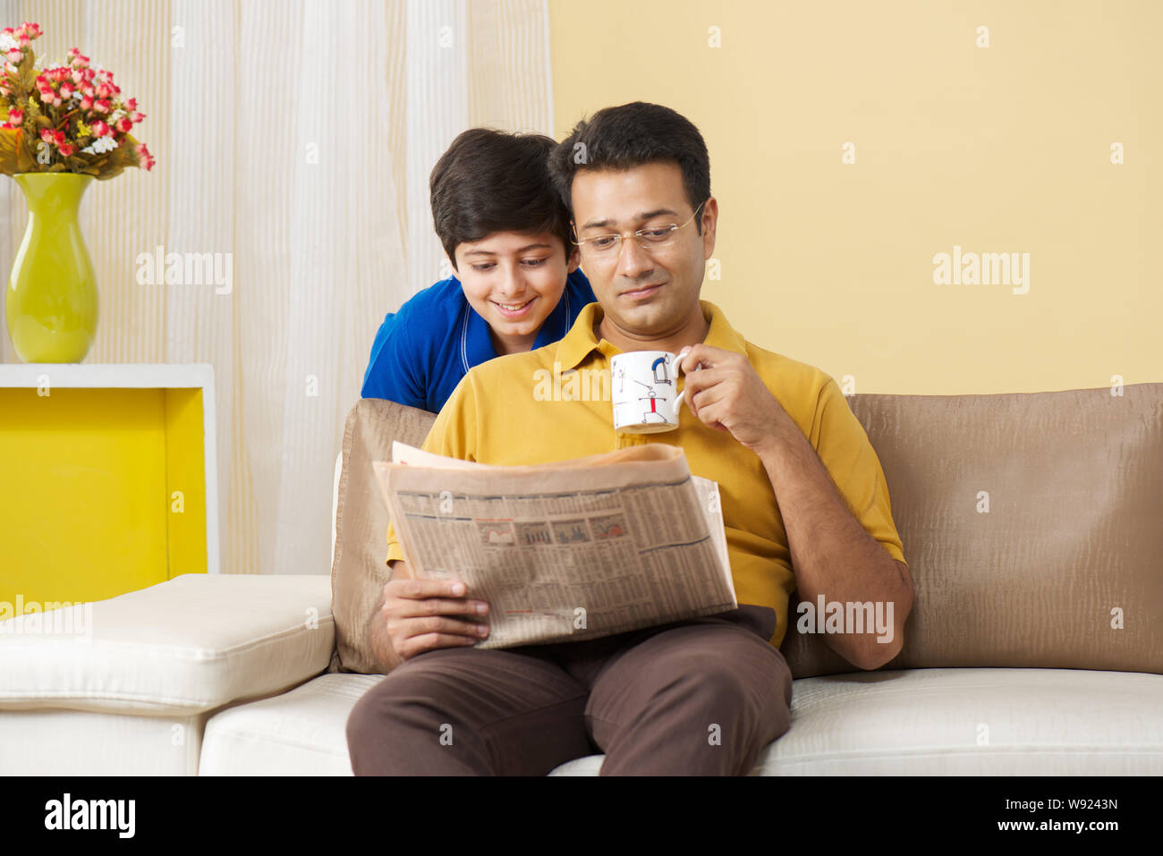 Father and son reading a newspaper Stock Photo - Alamy