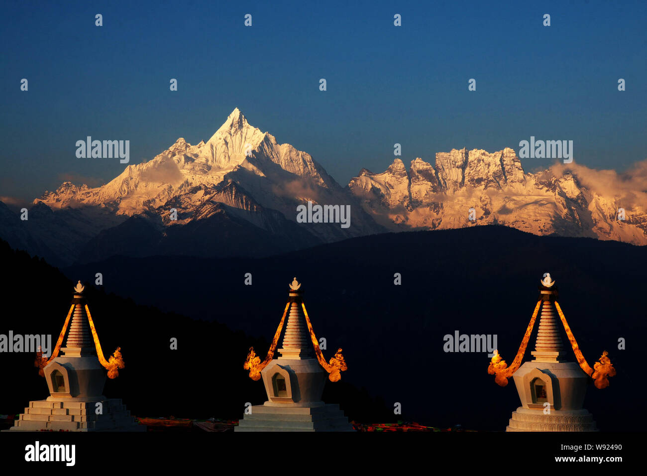Tibetan stupas are seen when the first rays of light hit the Kawagebo ...